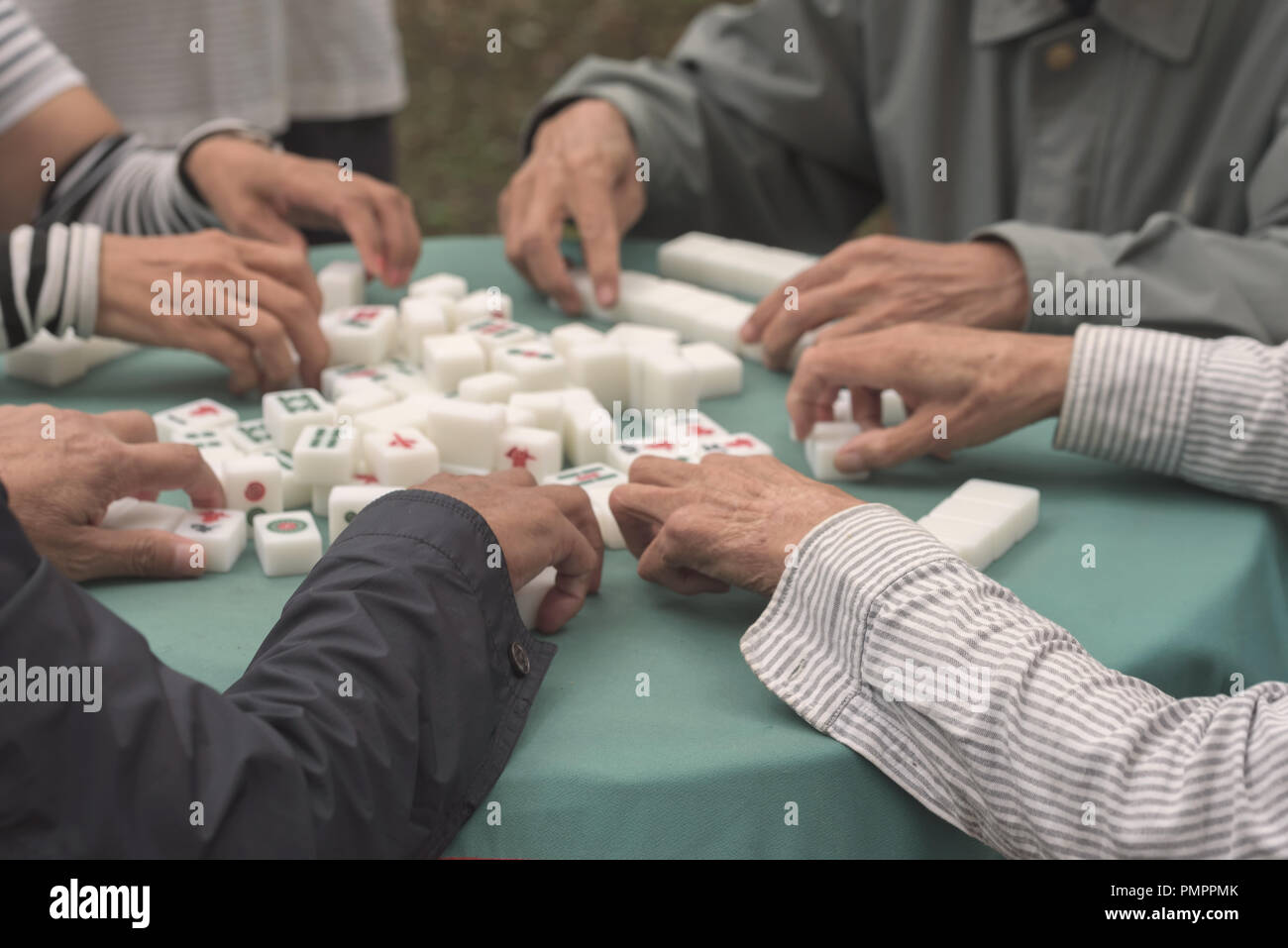 Mahjong board game. Playing Mahjong on table. People play a board game ...