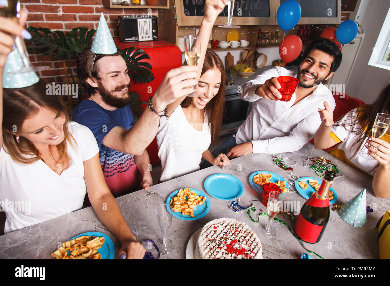Beautiful young people having fun at the party, wearing party hats ...