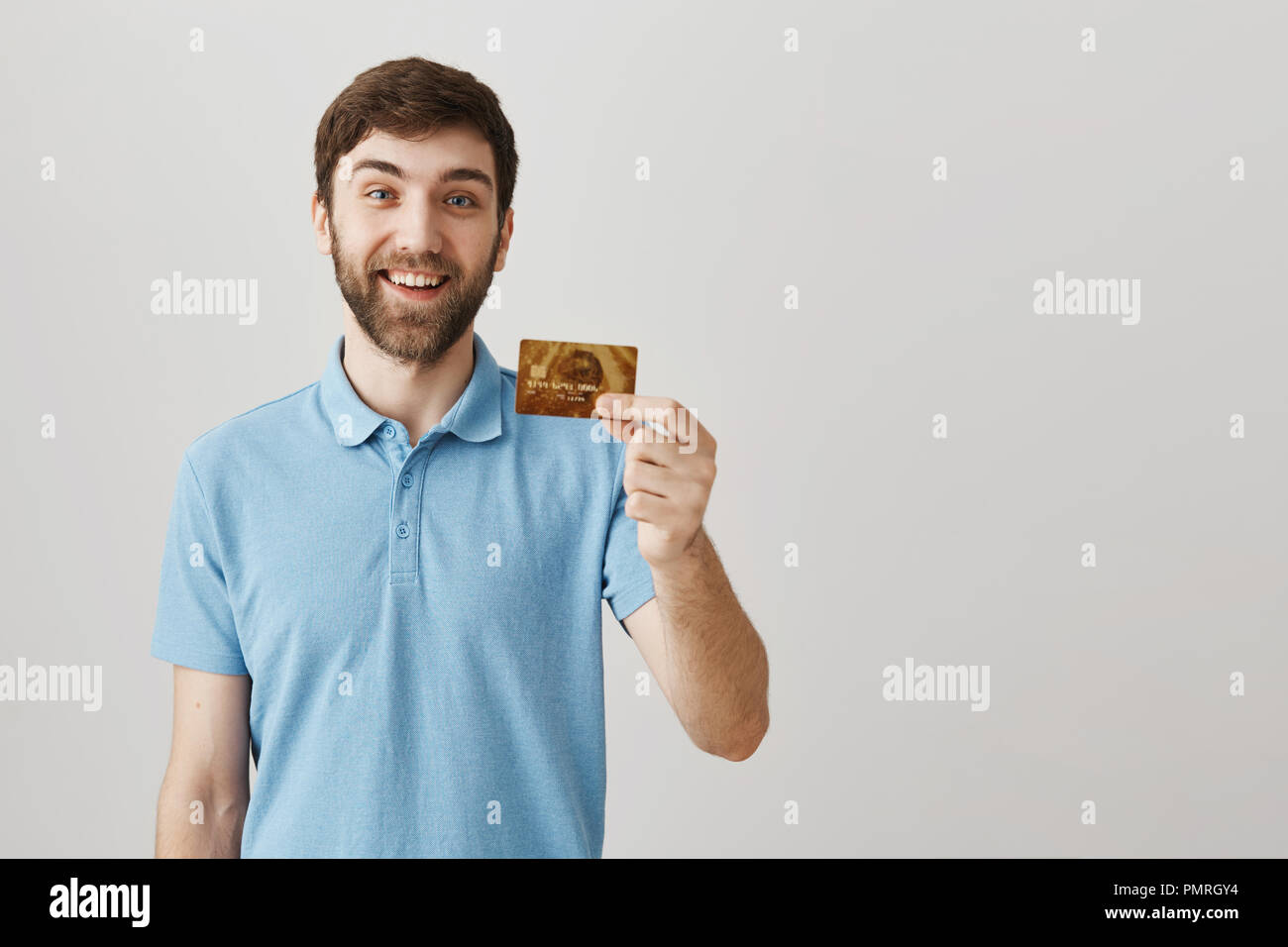 Best bank ever. Attractive young employee with beard showing credit ...