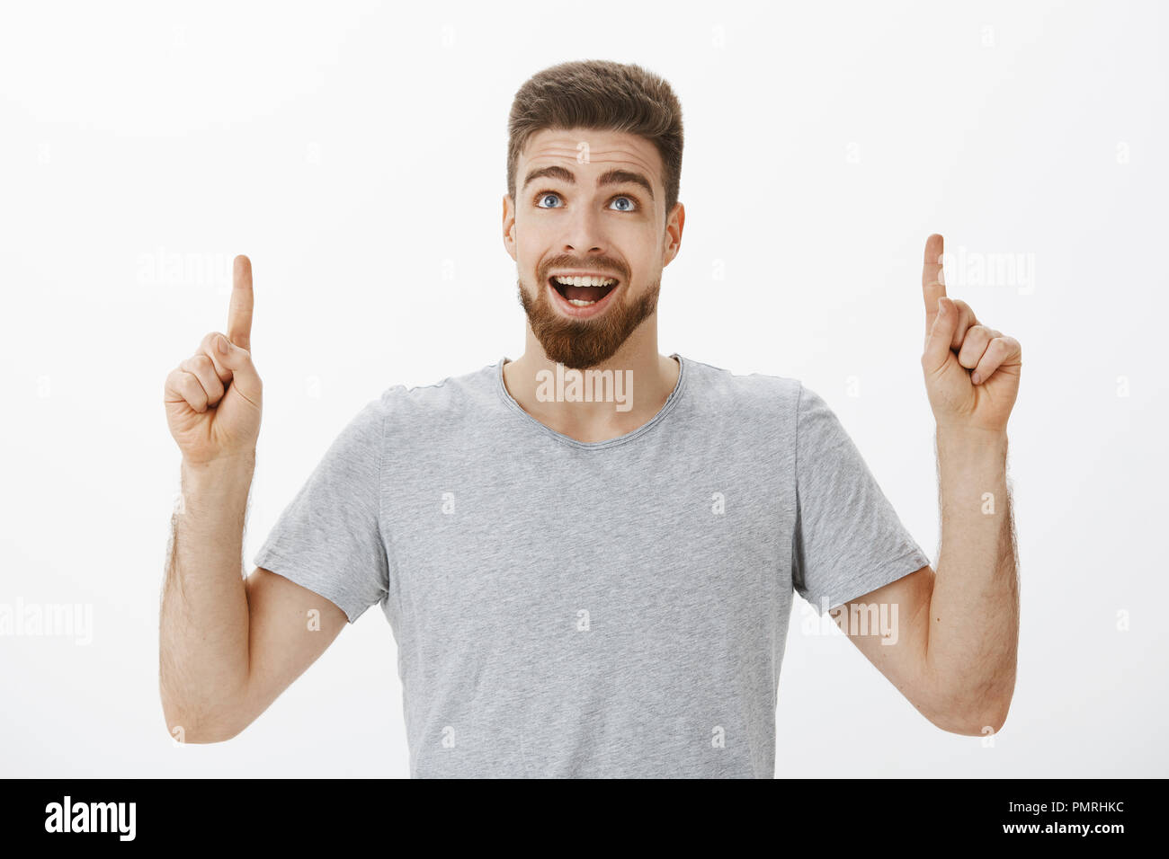 Indoor shot of dreamy and enthusiastic handsome young man having lots ...