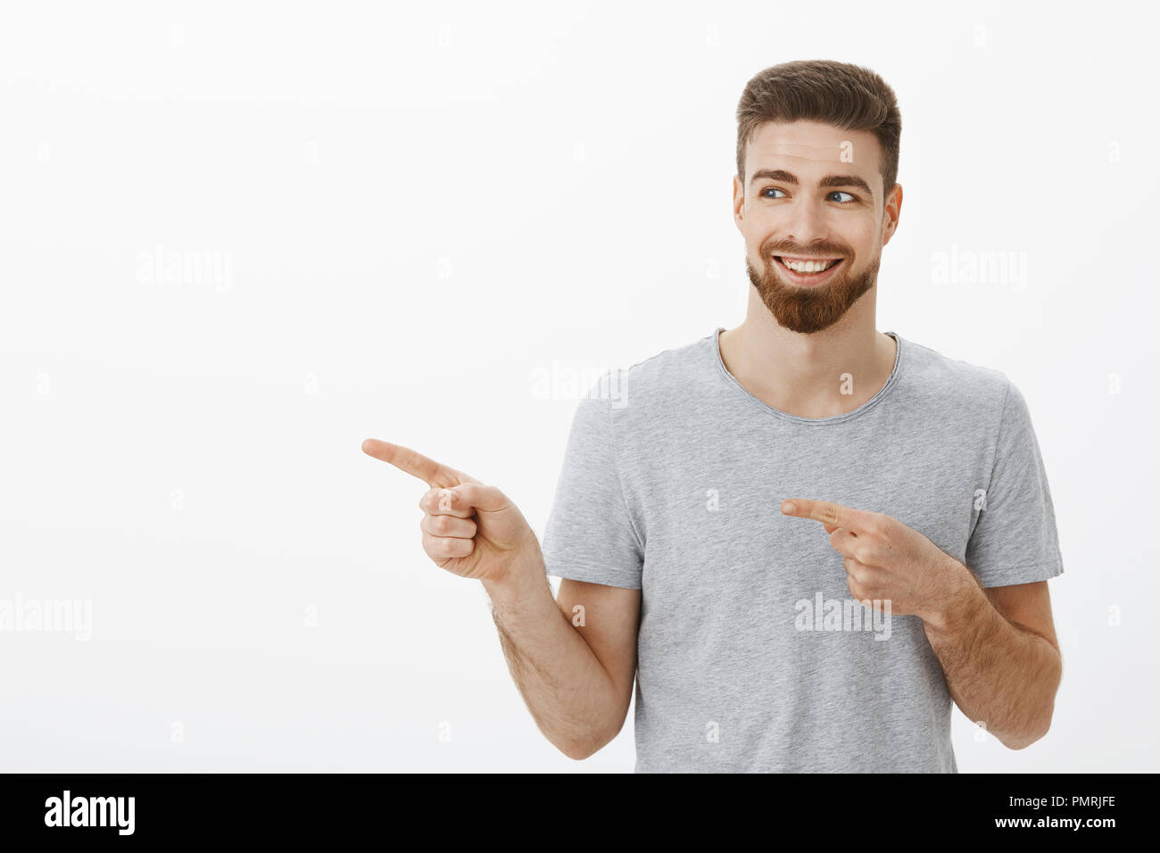 Studio shot of charming satisfied and happy young male with beard and ...