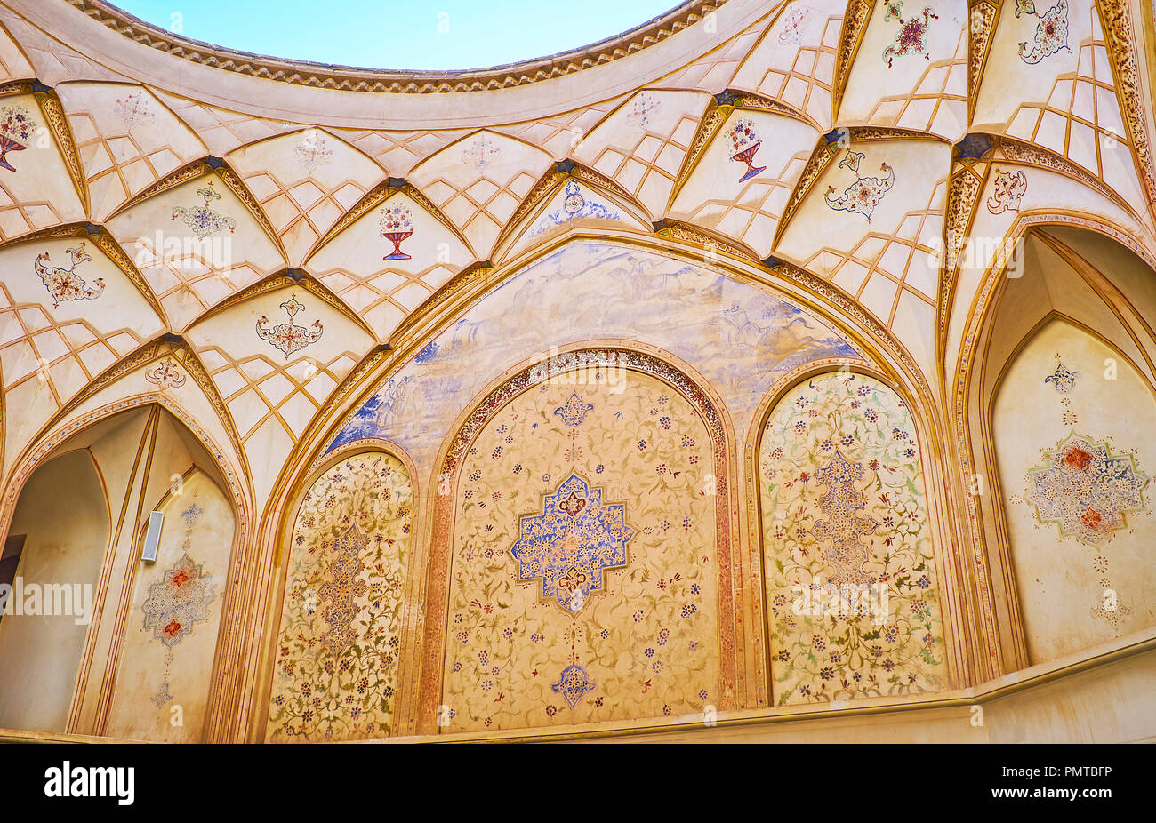 KASHAN, IRAN - OCTOBER 22, 2017: The old frescoes on wall and honeycomb dome of a room in ...