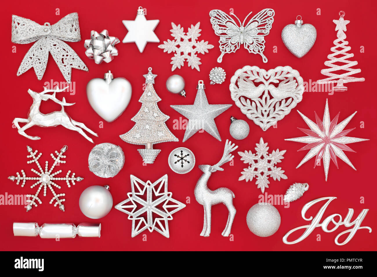 Symbols of Christmas with silver joy sign and bauble decorations on red ...