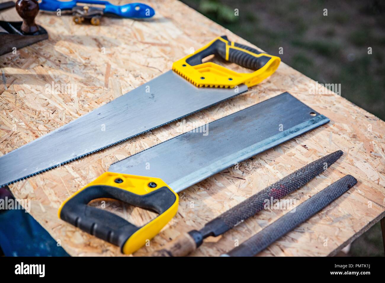 Metallic carpenter's saw and tools on wooden table. Wood work Stock ...