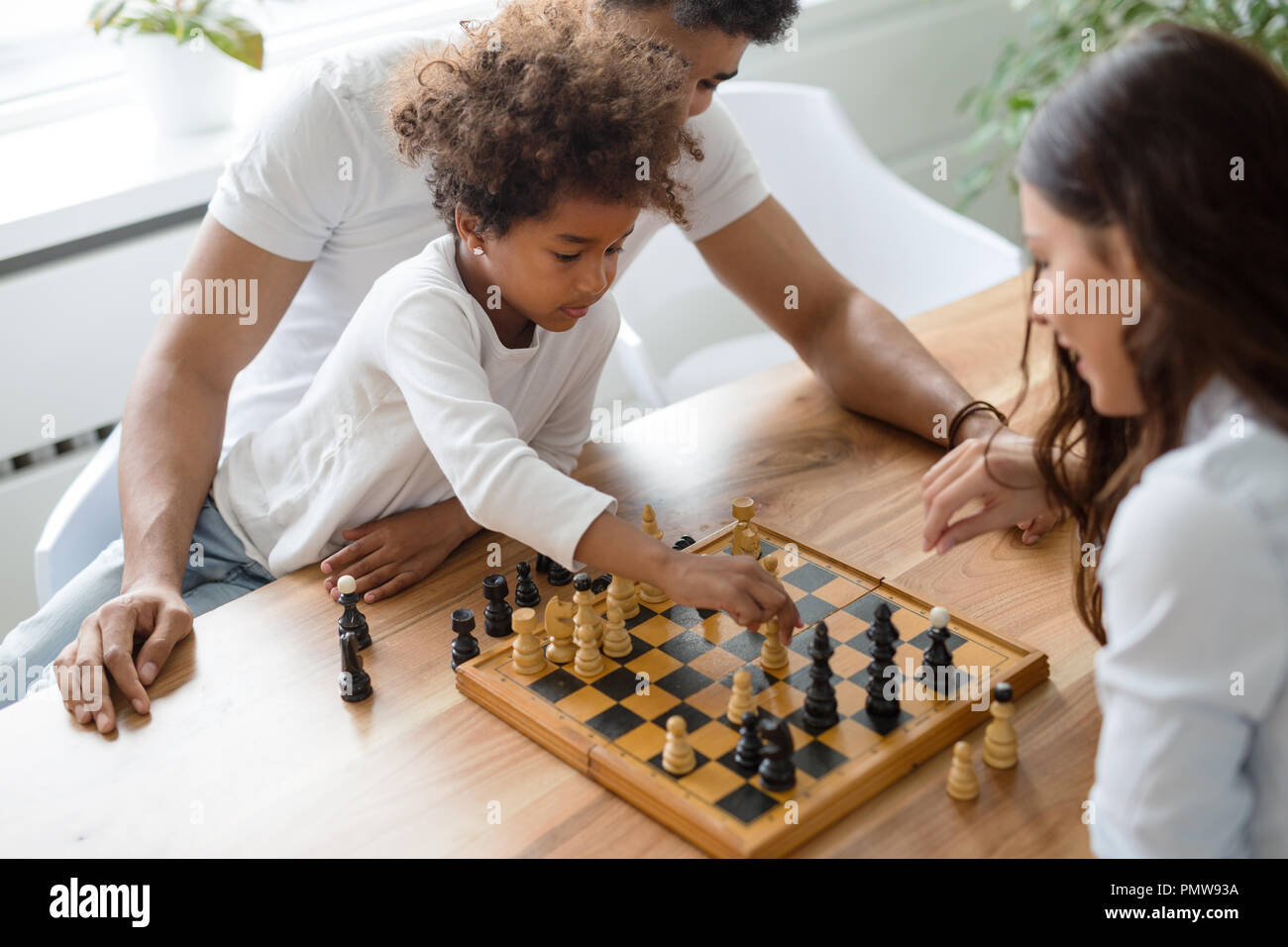 Happy family playing chess together at home Stock Photo - Alamy