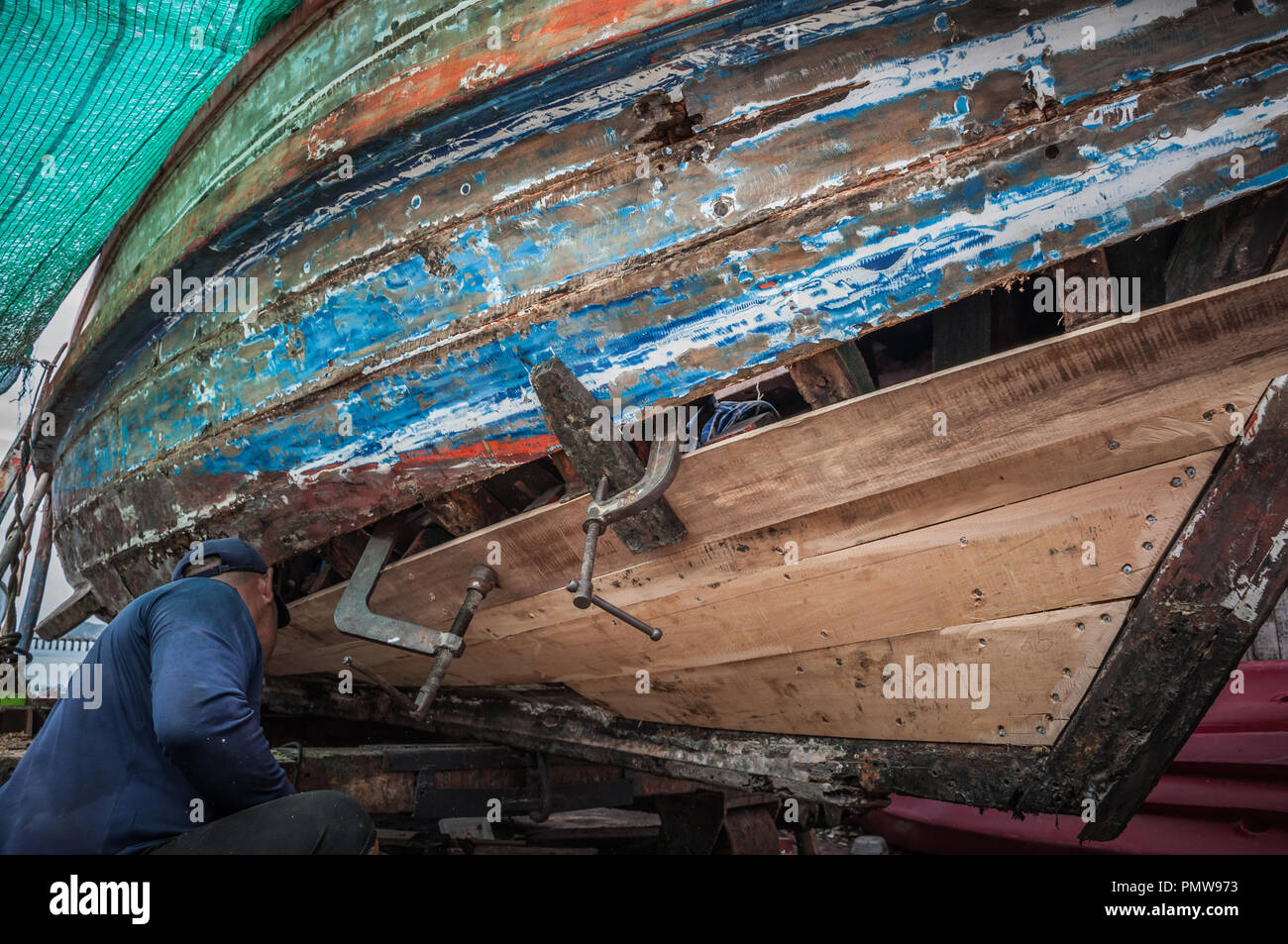 Mechanic maintenance old wood boat on beach with hand, fishery ...