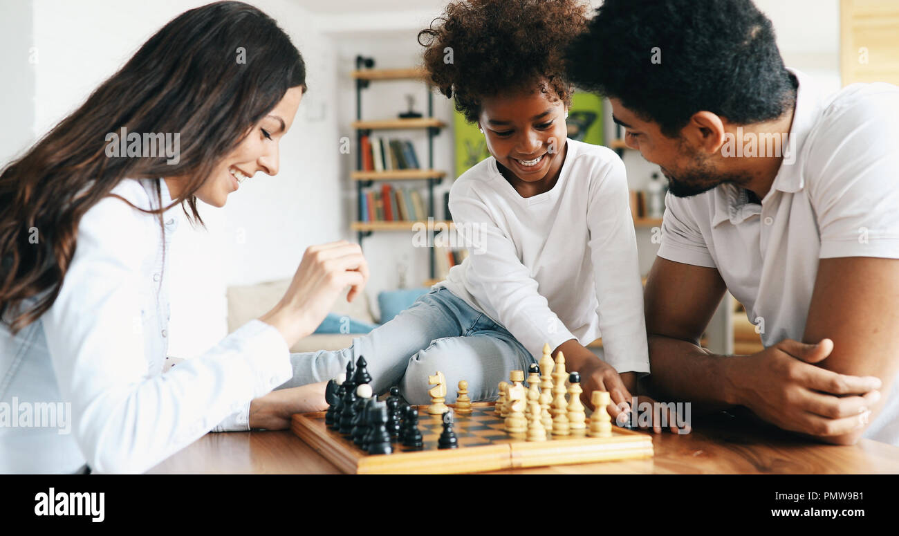 Happy family playing chess together at home Stock Photo - Alamy
