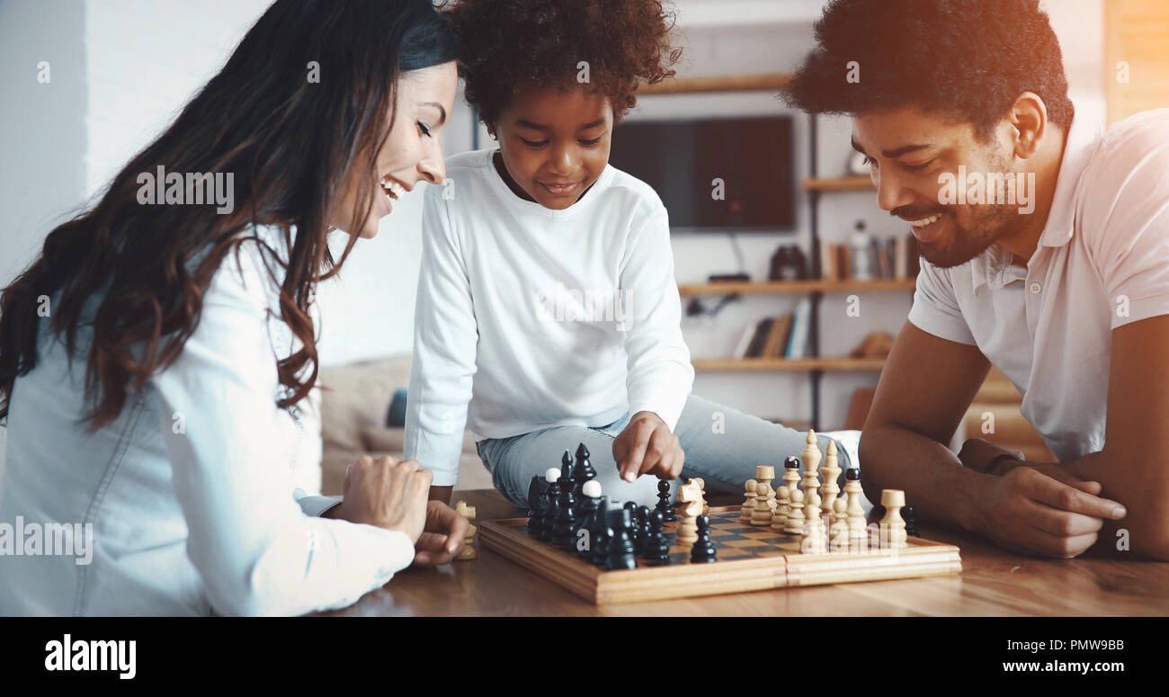 Happy family playing chess together at home Stock Photo - Alamy