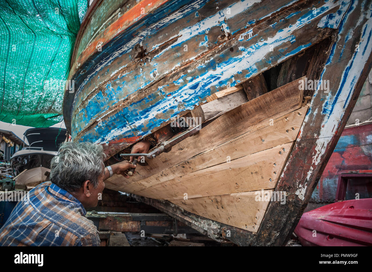 Mechanic maintenance old wood boat on beach with hand, fishery ...