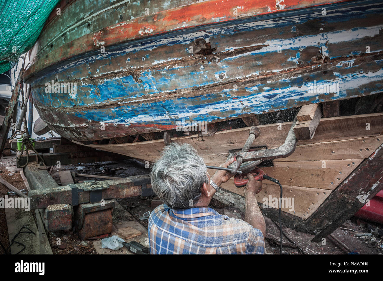 Mechanic maintenance old wood boat on beach with hand, fishery ...