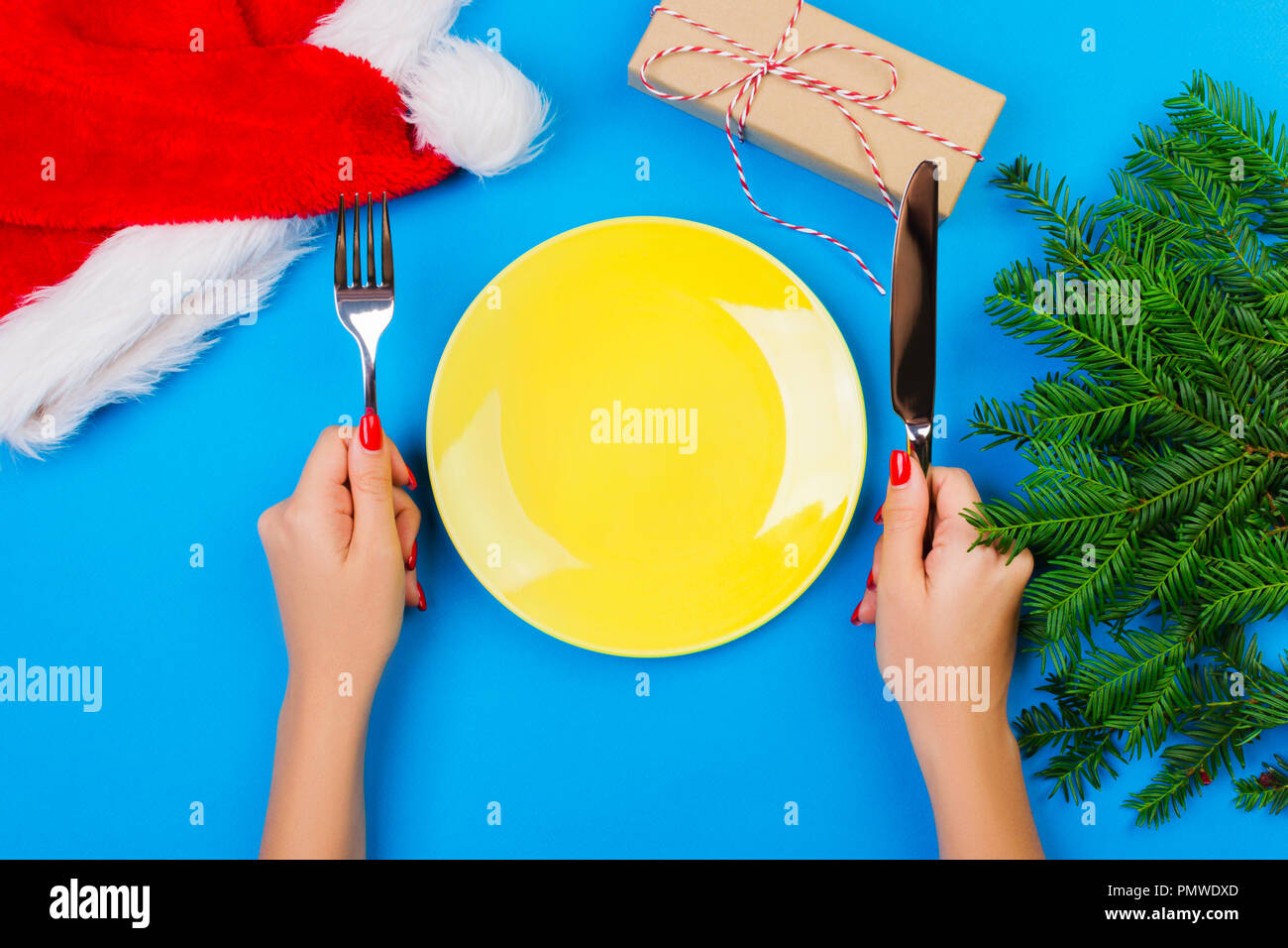 Hungry woman waiting for meal. empty yellow plate on a blue background ...