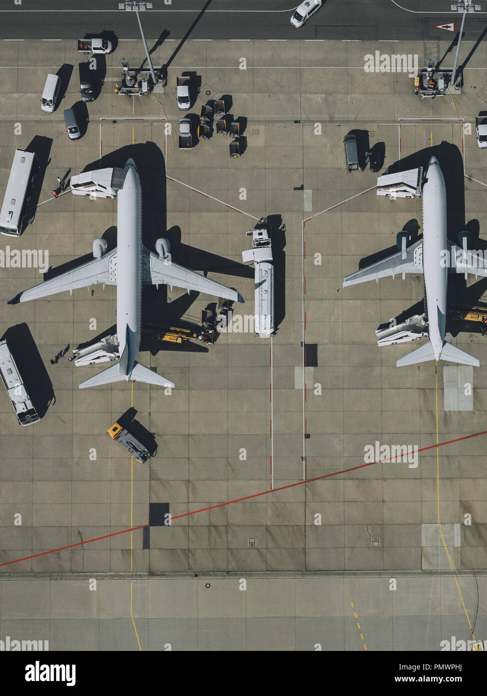 View from above commercial airplanes being serviced, prepared on tarmac ...