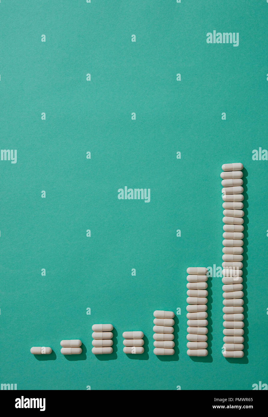 Capsules forming ascending bar graph on green background Stock Photo ...
