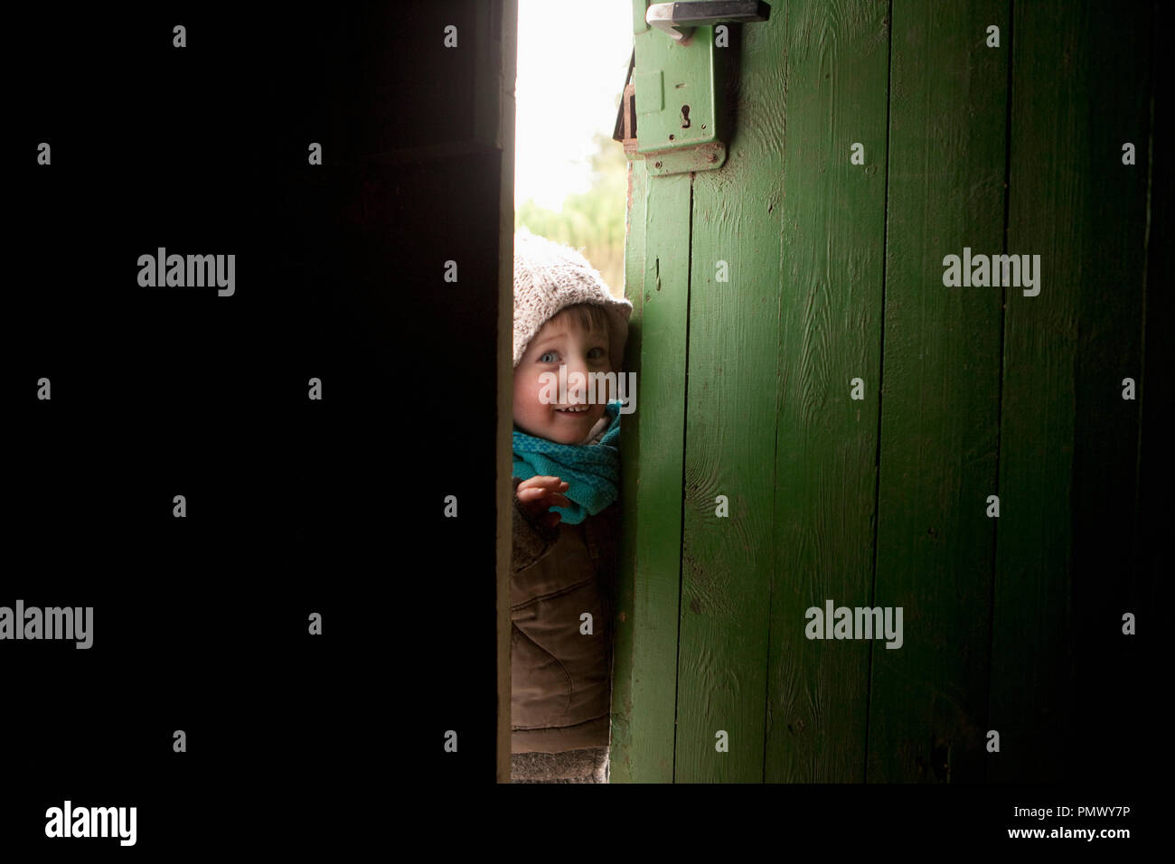 Portrait cute, curious girl opening door Stock Photo - Alamy