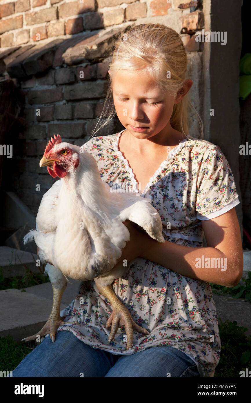 Girl holding rooster Stock Photo - Alamy