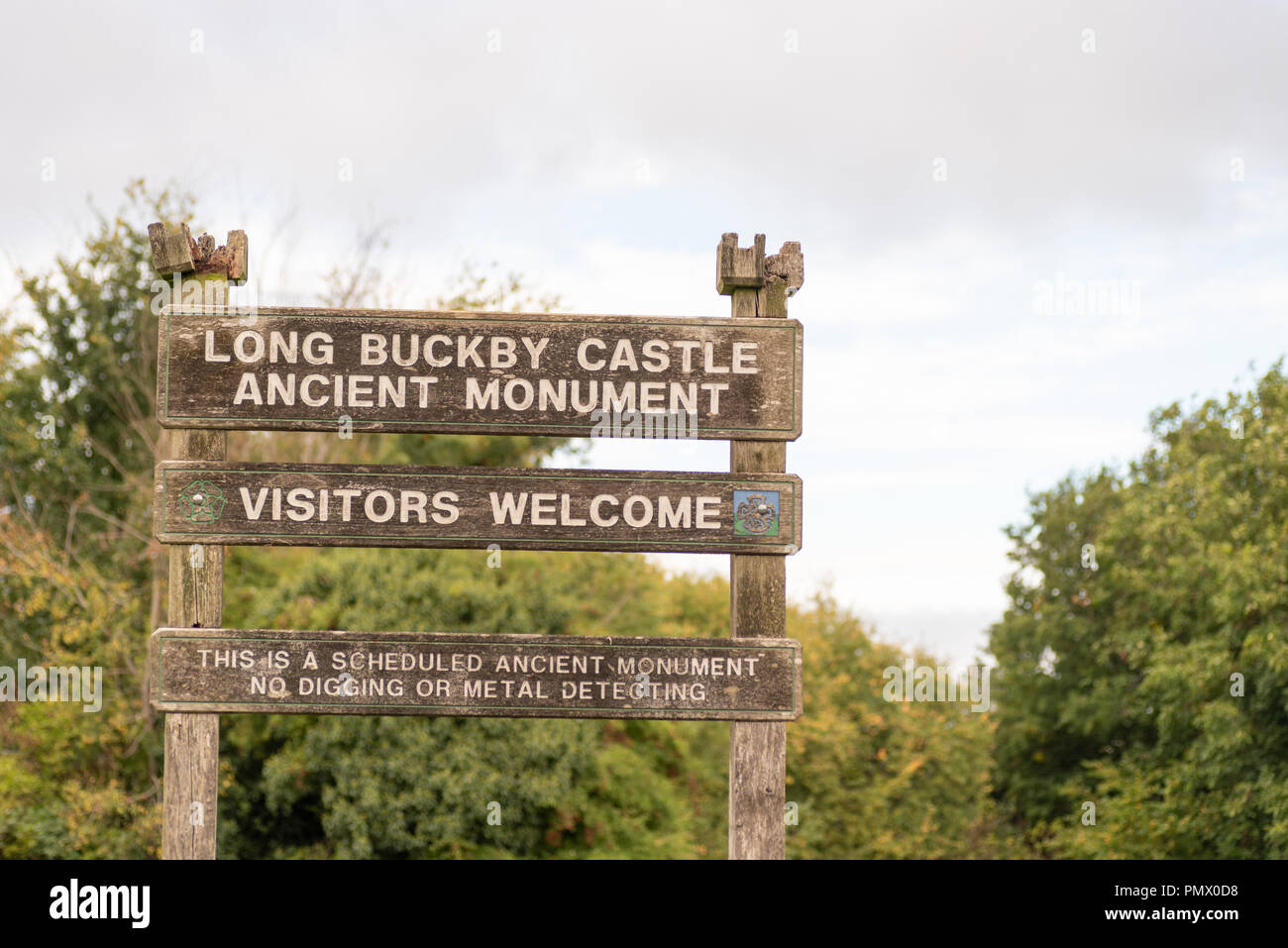 Old wooden public footpath sign post with long buckby ancient castle ...