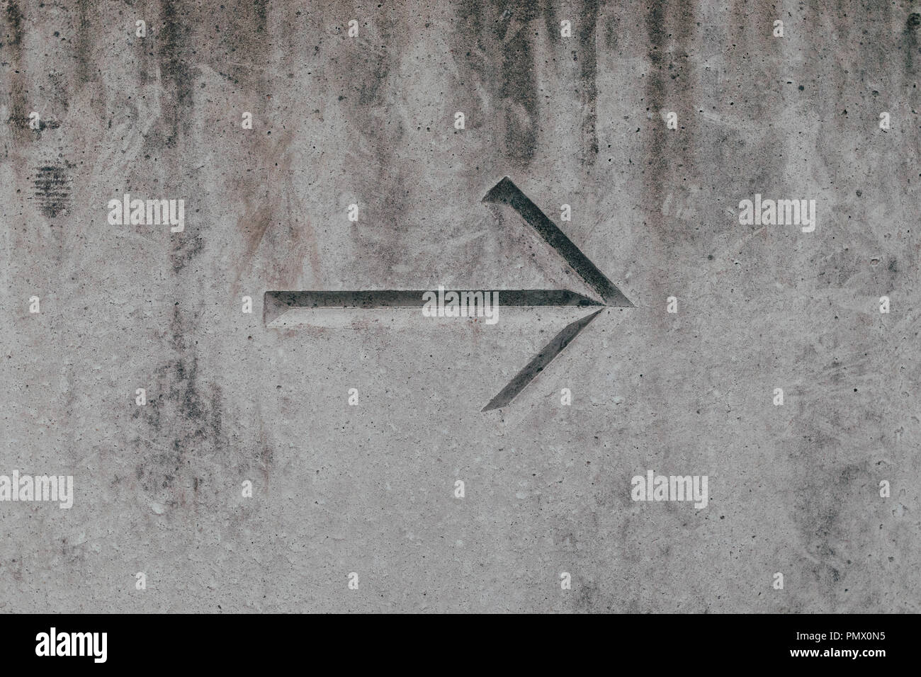 Arrow on concrete wall Stock Photo - Alamy