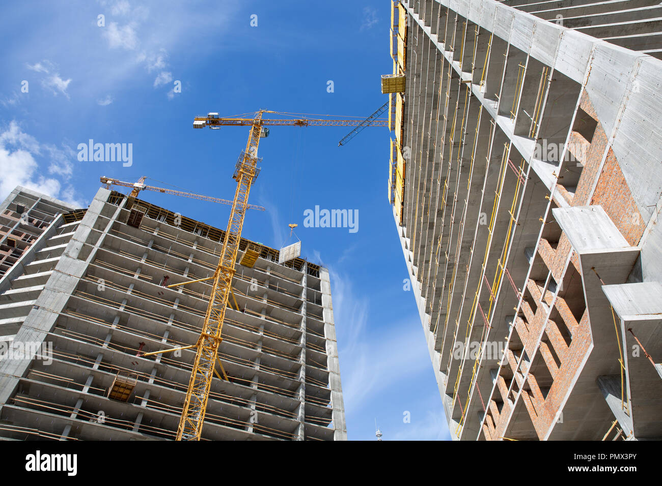 modern urban buildings under construction with a crane and blue sky ...