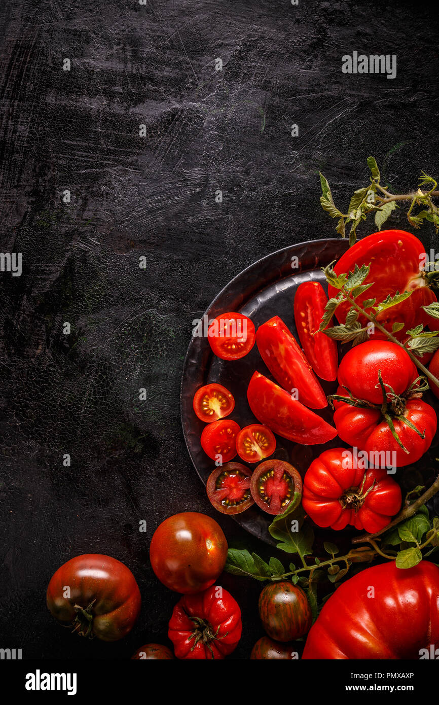 Flat lay of fresh ripe tomatoes on black background Stock Photo - Alamy