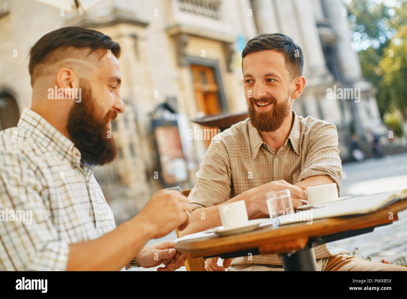 two businessmen drink coffee at a cafe Stock Photo - Alamy
