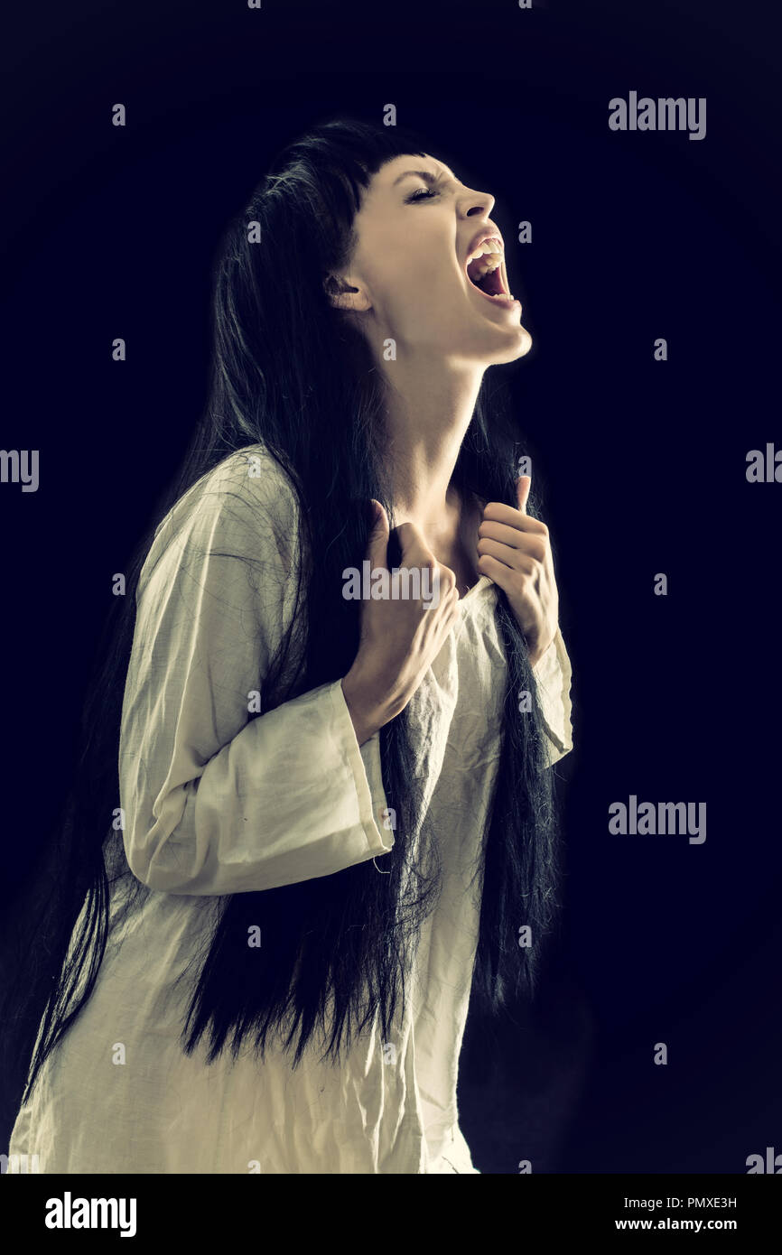 Halloween zombie woman screaming on black background at night at ...