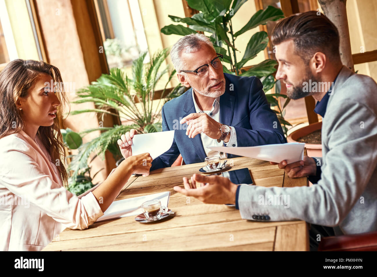 Business lunch. Three people in the restaurant sitting at table ...