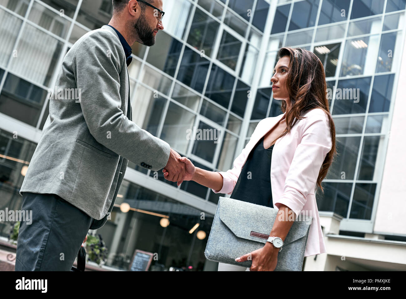 Making deal. Two young business people standing outside on the city ...