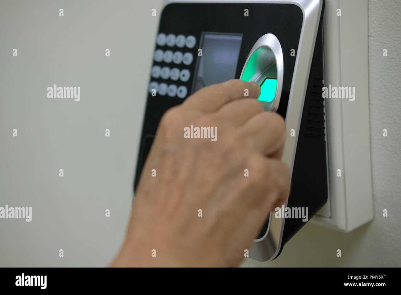 hand scanning finger print on access control machine. hour work time ...