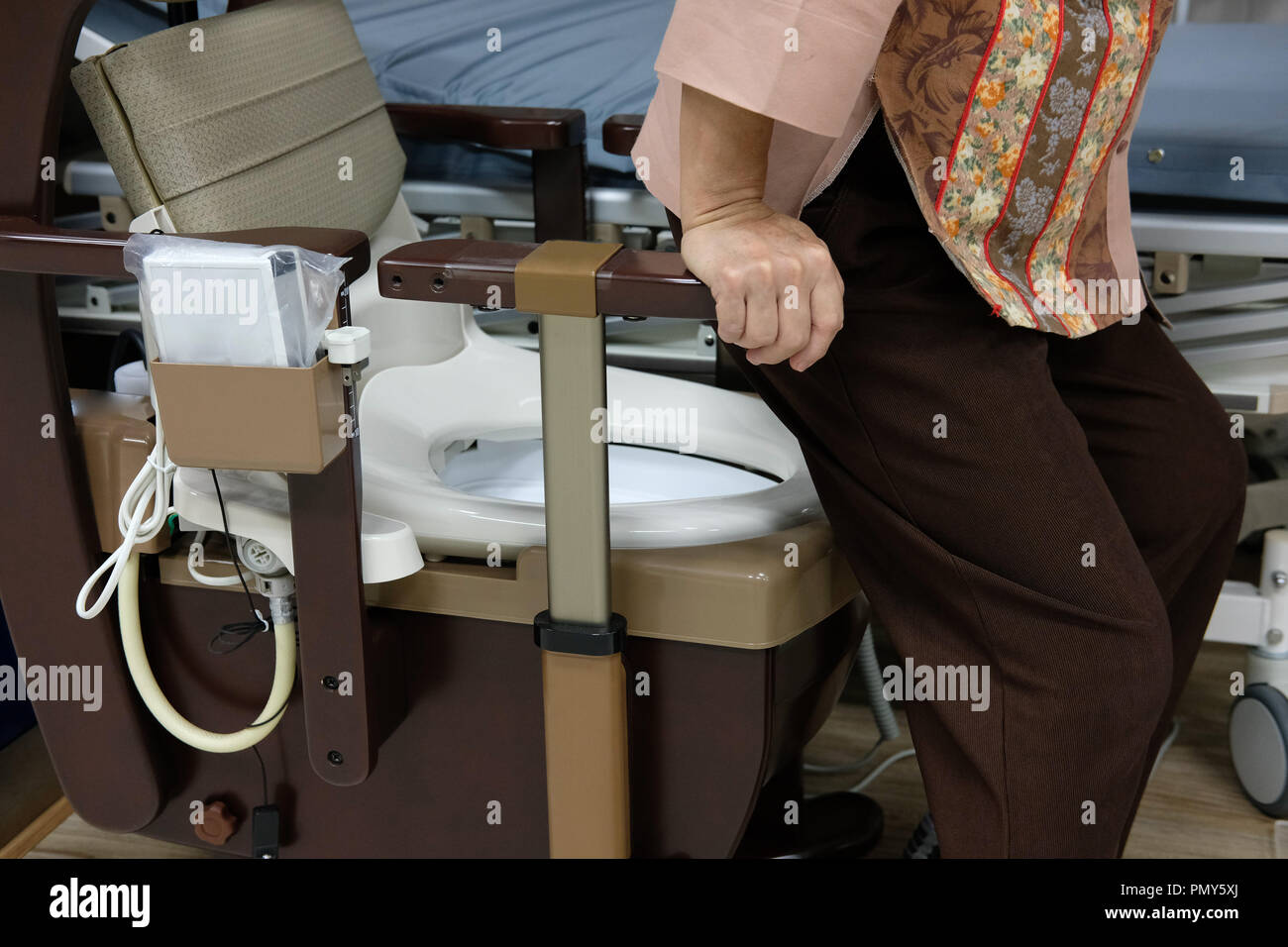 old woman use portable mobile plastic toilet near patient bed at ...