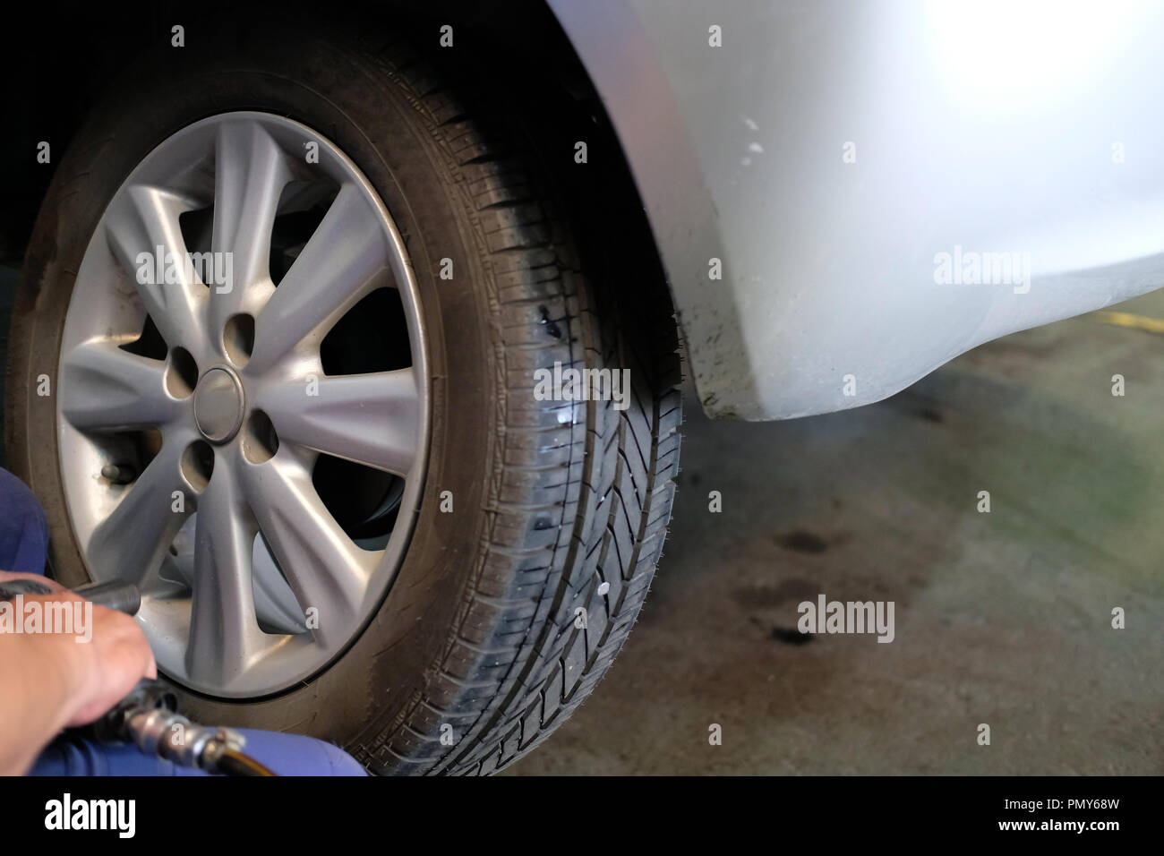 Mechanic changing car wheel in auto repair shop. serviceman replace ...