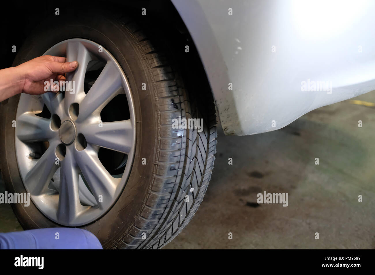 Mechanic changing car wheel in auto repair shop. serviceman replace ...