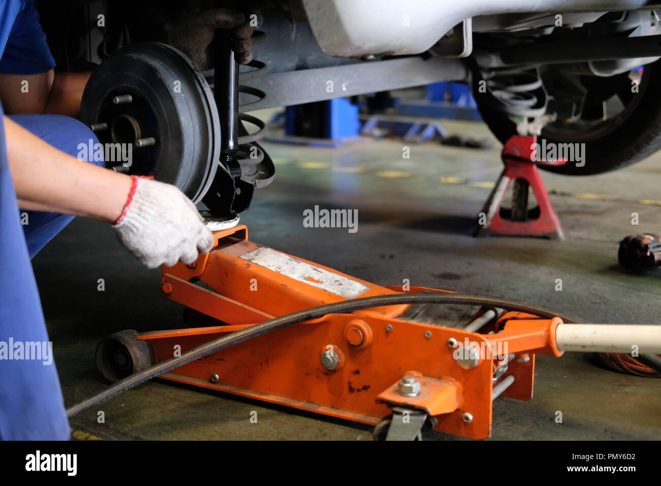 mechanic replace shock absorber & spring in auto service repair garage ...