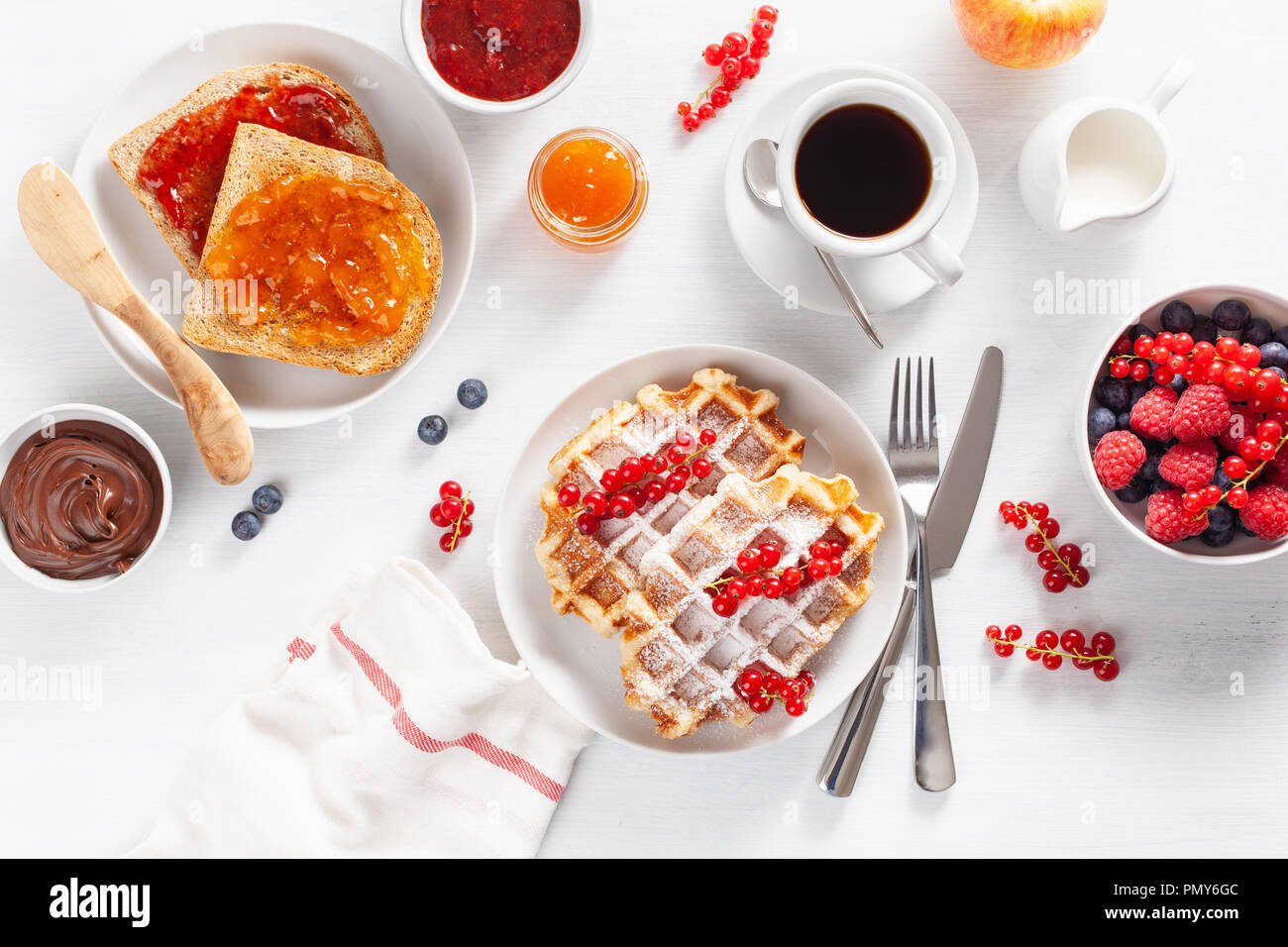 breakfast with waffle, toast, berry, jam, chocolate spread and coffee ...