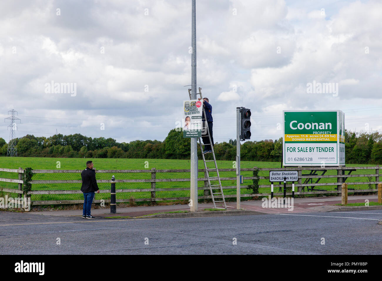 Celbridge, Ireland: Men hanging up a billboard advertising public ...