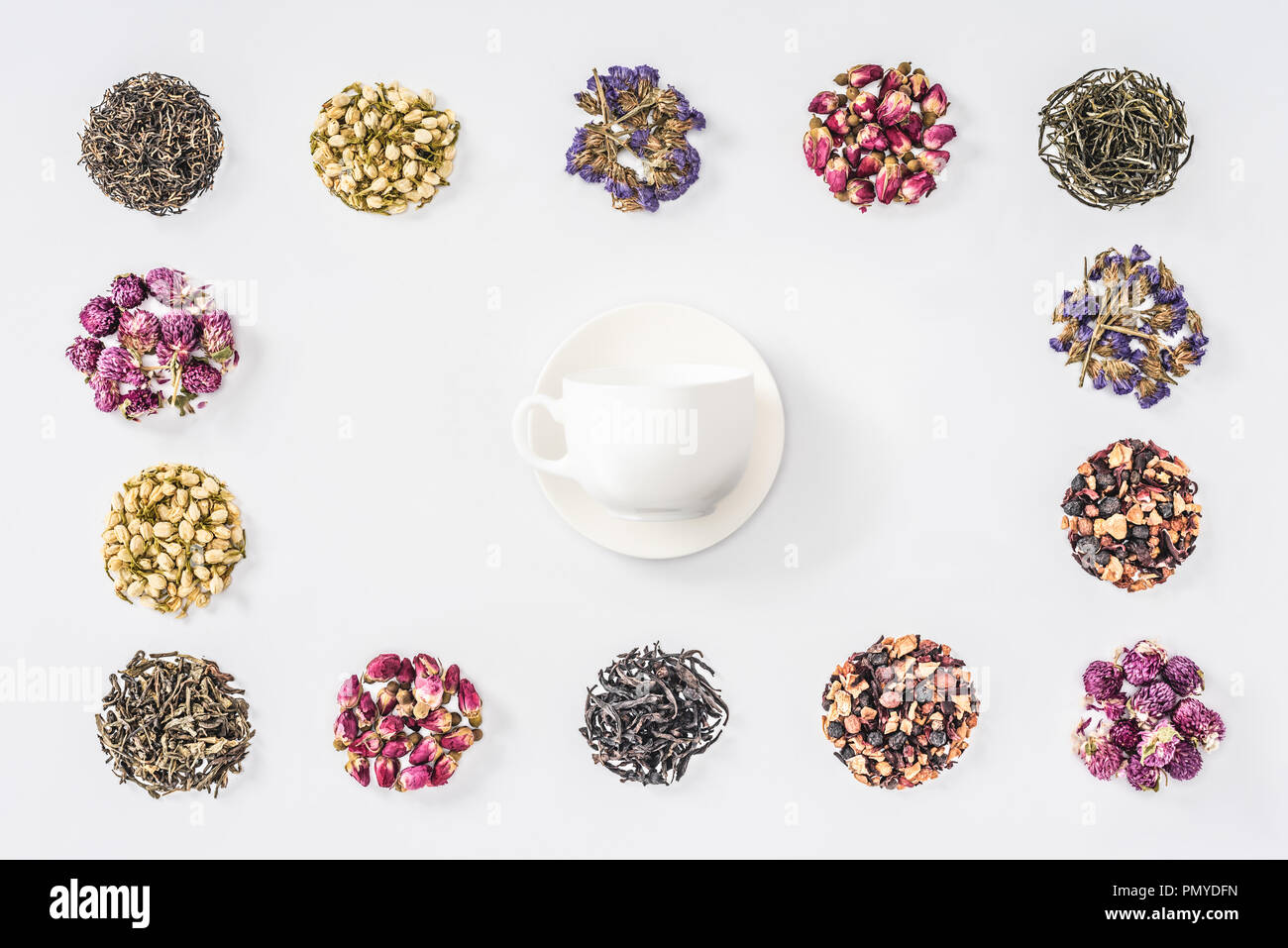 elevated view of cup and plate in frame of dried herbal organic tea ...