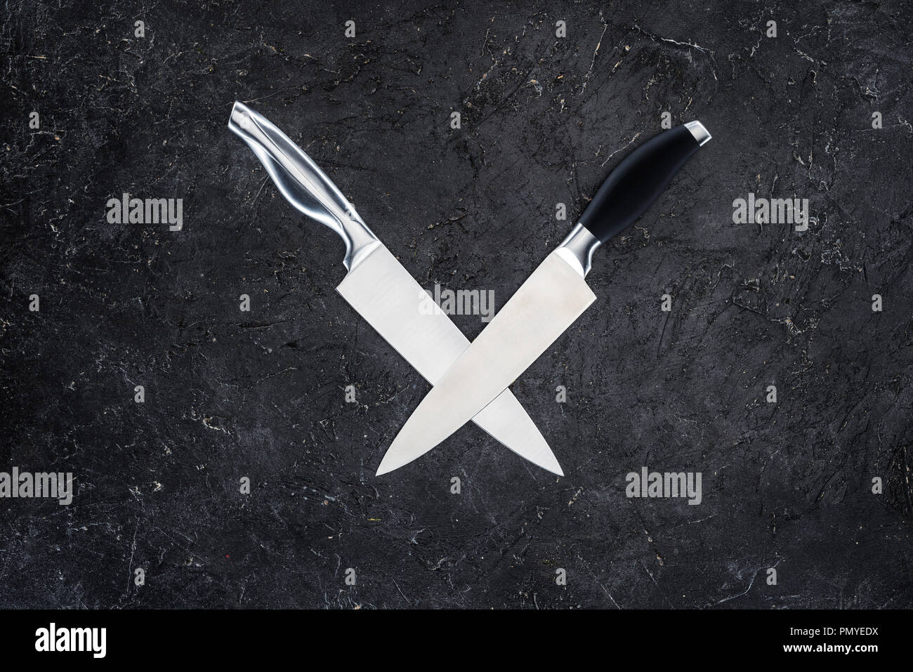 top view of two kitchen knives arranged on black surface Stock Photo ...