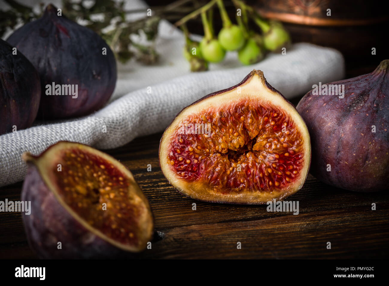 Half ripe and juicy fig lying on rustic table. Seasonal and exotic ...