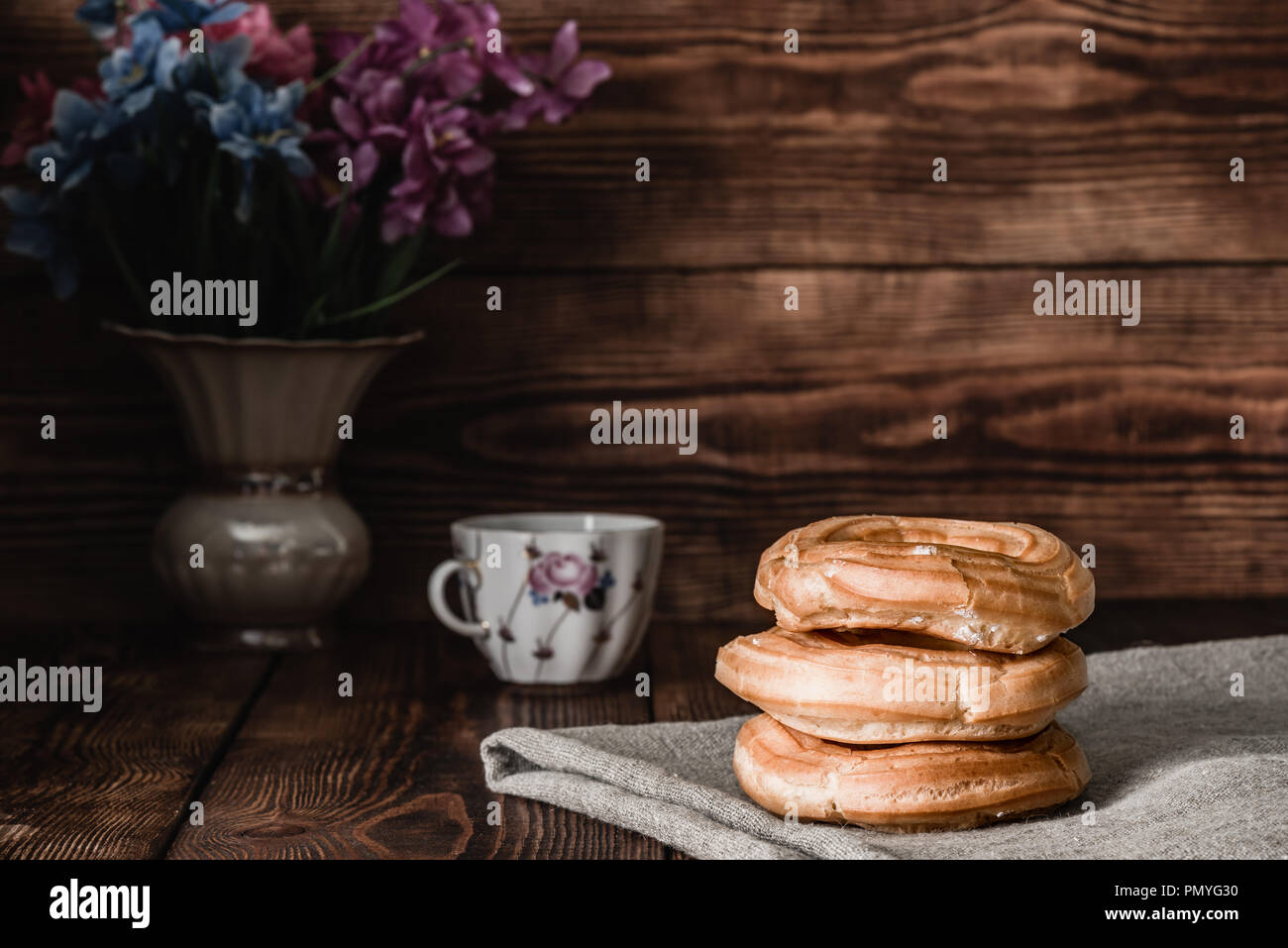 Eclairs stack on table with cup of coffee and vase of flowers Stock ...