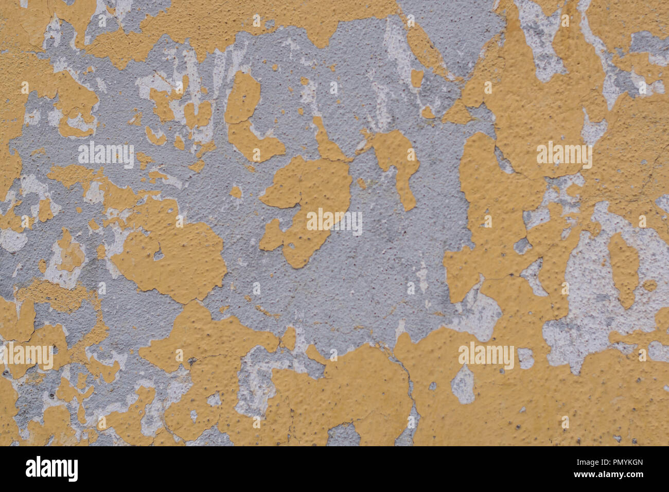 Isolated shot of yellow, grey and white chipping paint, on a stucco ...