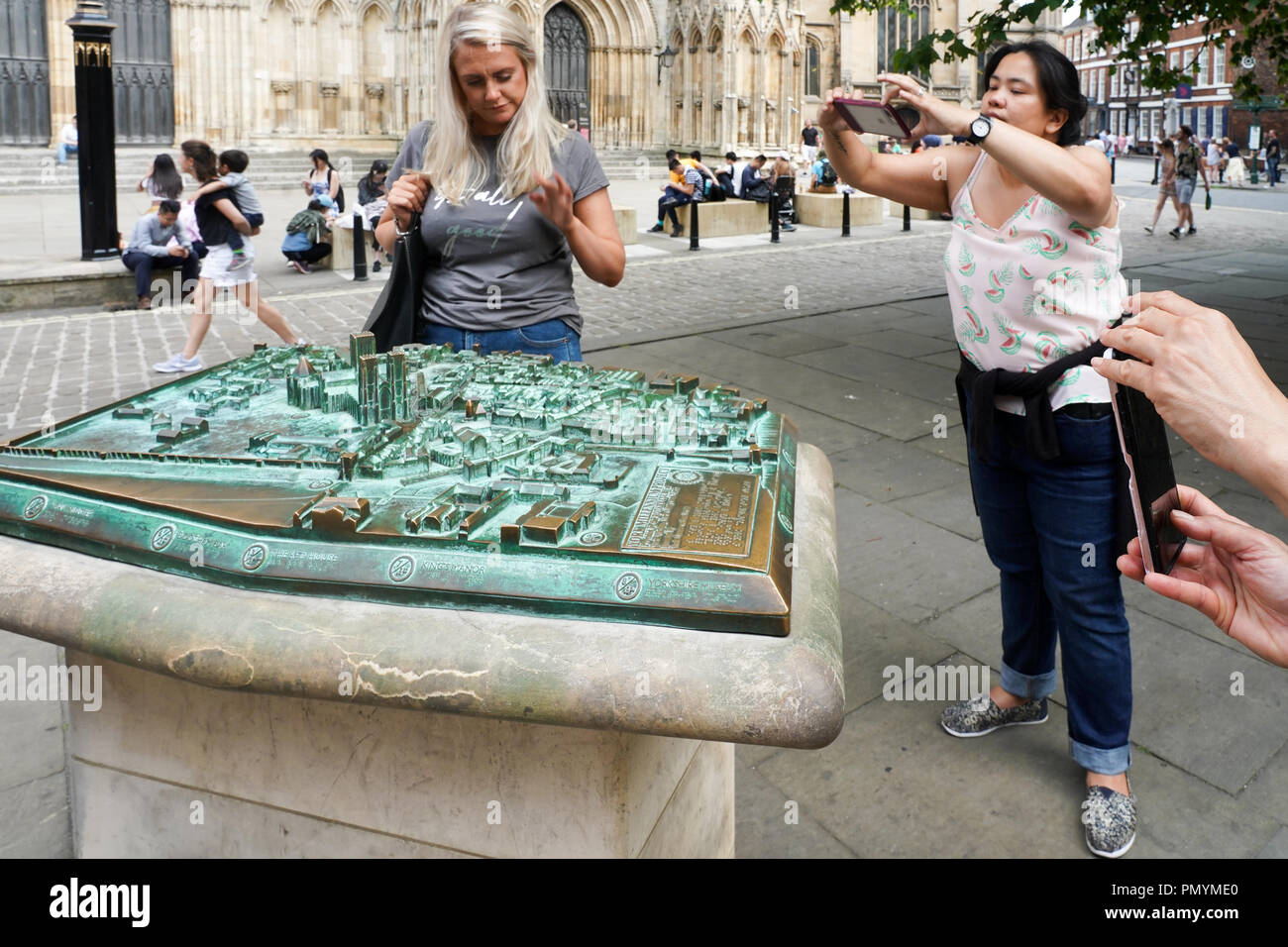 Tourists taking photos of a model of York Minster in York in Yorkshire ...