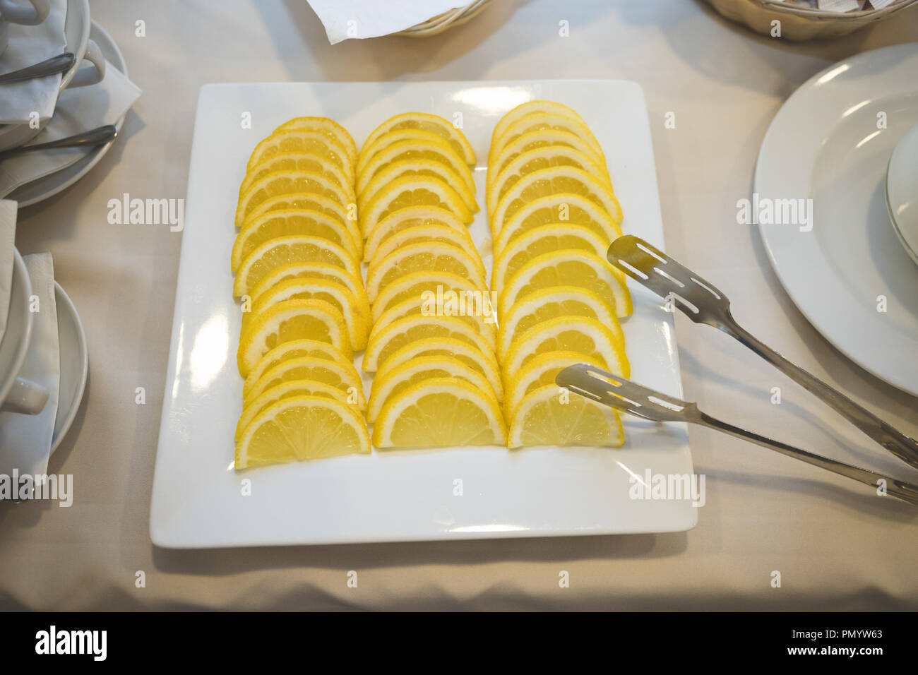 Lemon slices in a square plate on the dining table Stock Photo - Alamy