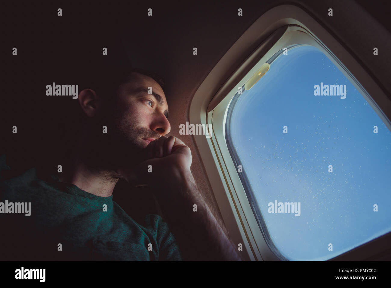 Pensive man looking outside through the window of an airplane Stock ...