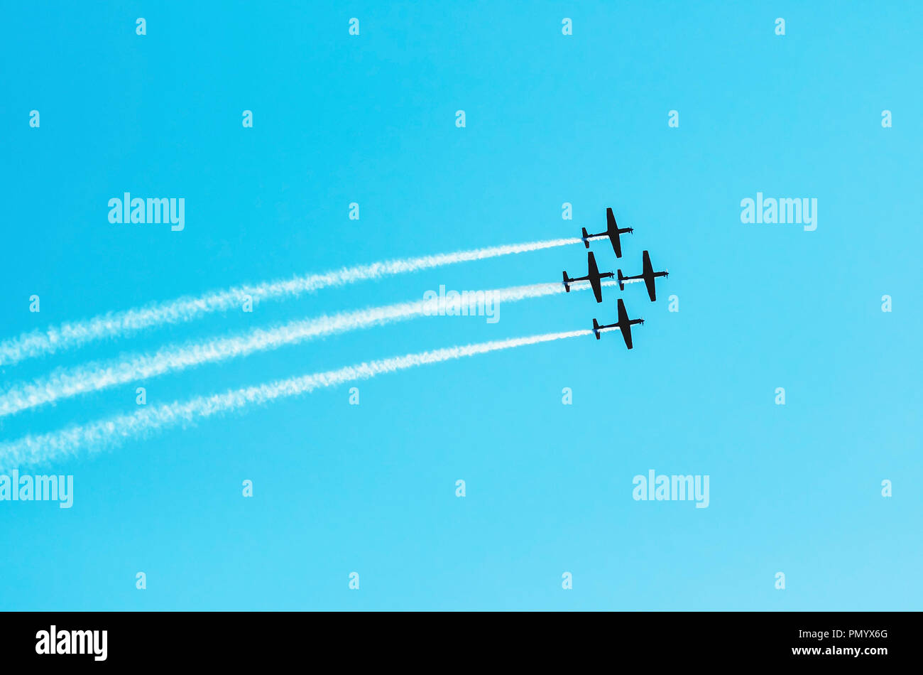 Squad of four airplanes flying together leaving a smoke trail behind ...