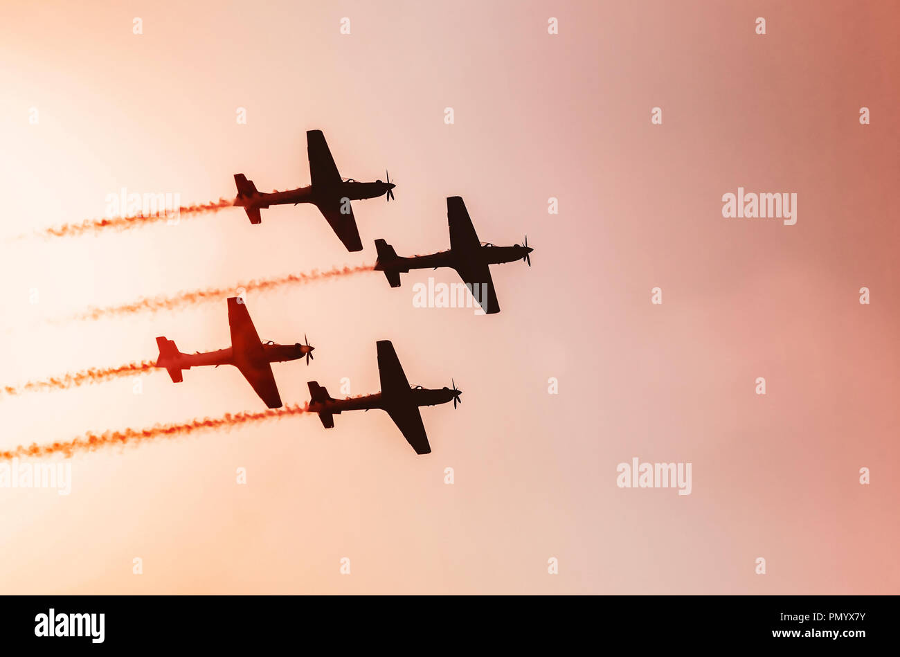 Squad Of Four Airplanes Flying Together Leaving A Smoke Trail Behind Photo At A Sunset Warm squad-of-four-airplanes-flying-together-leaving-a-smoke-trail-behind-photo-at-a-sunset-warm