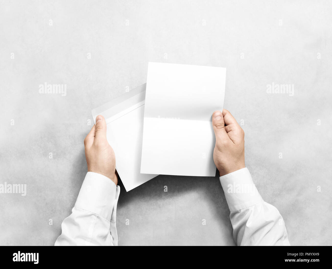 Hand holding white blank envelope and letter mockup, isolated. Arm hold ...