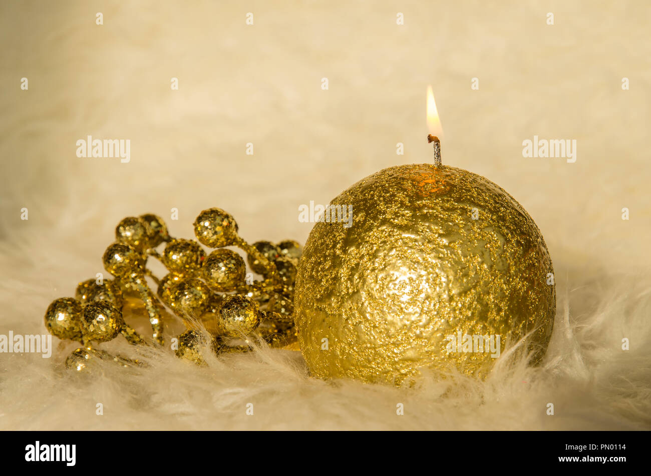 one golden burning candle against white background Stock Photo - Alamy