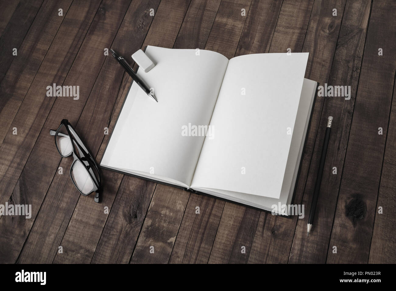 Blank open book and stationery on wood table background. Responsive ...