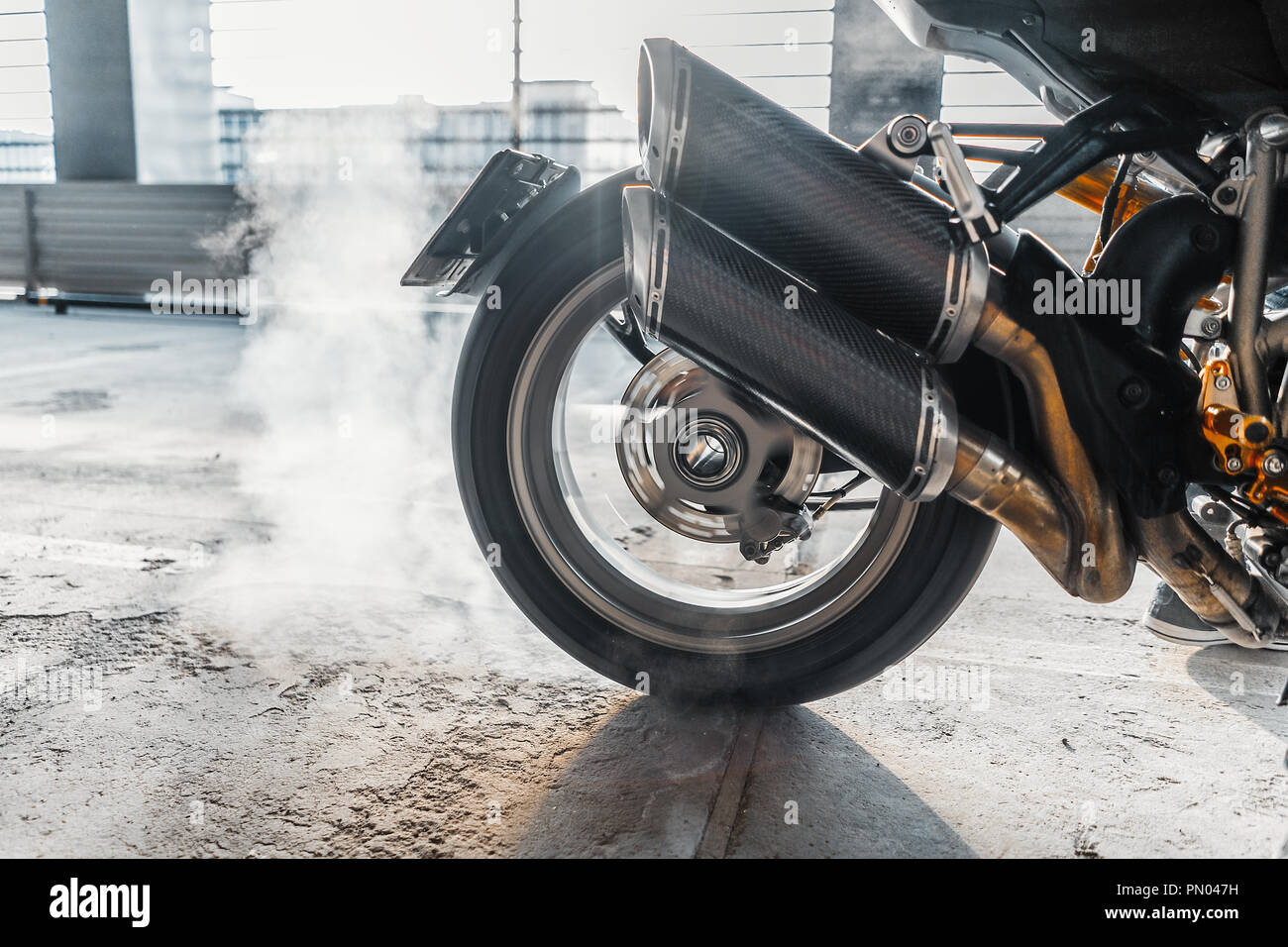 Close up of motorcycle wheel burnout at parking Stock Photo - Alamy