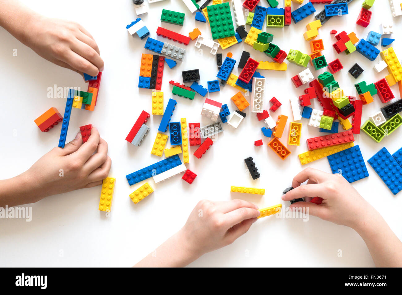 Children hands play with colorful lego blocks on white table Stock ...