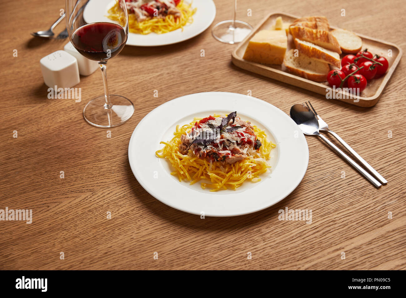 close-up shot of plates of spaghetti with red wine in glasses for ...